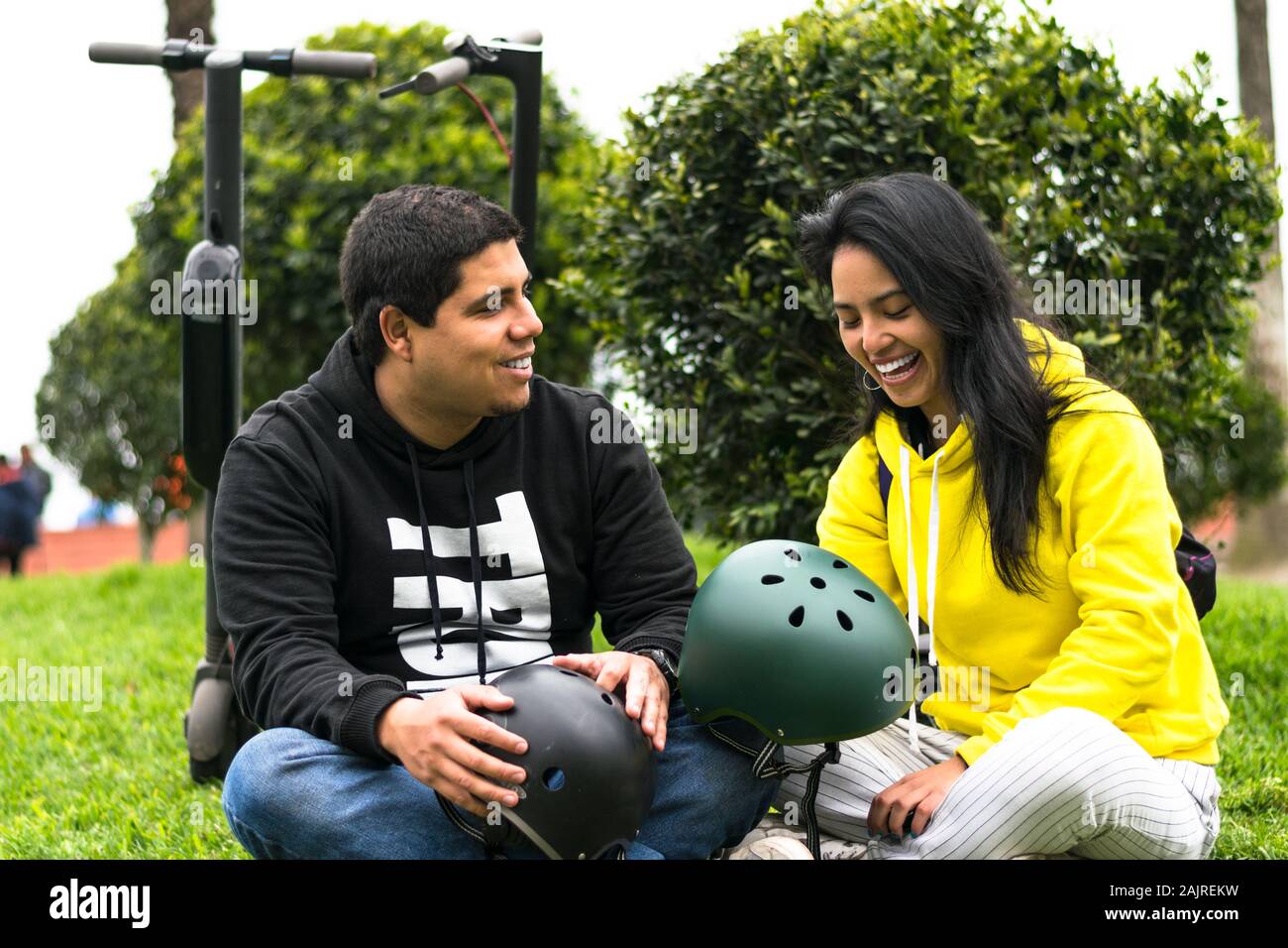 Two smiling friends showing helmet, concept in driving safety with a ...