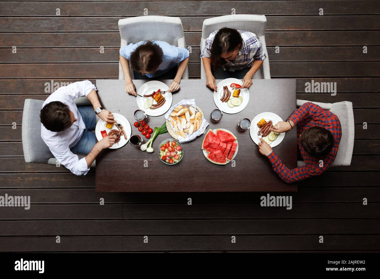 Four friends having dinner, top view Stock Photo - Alamy
