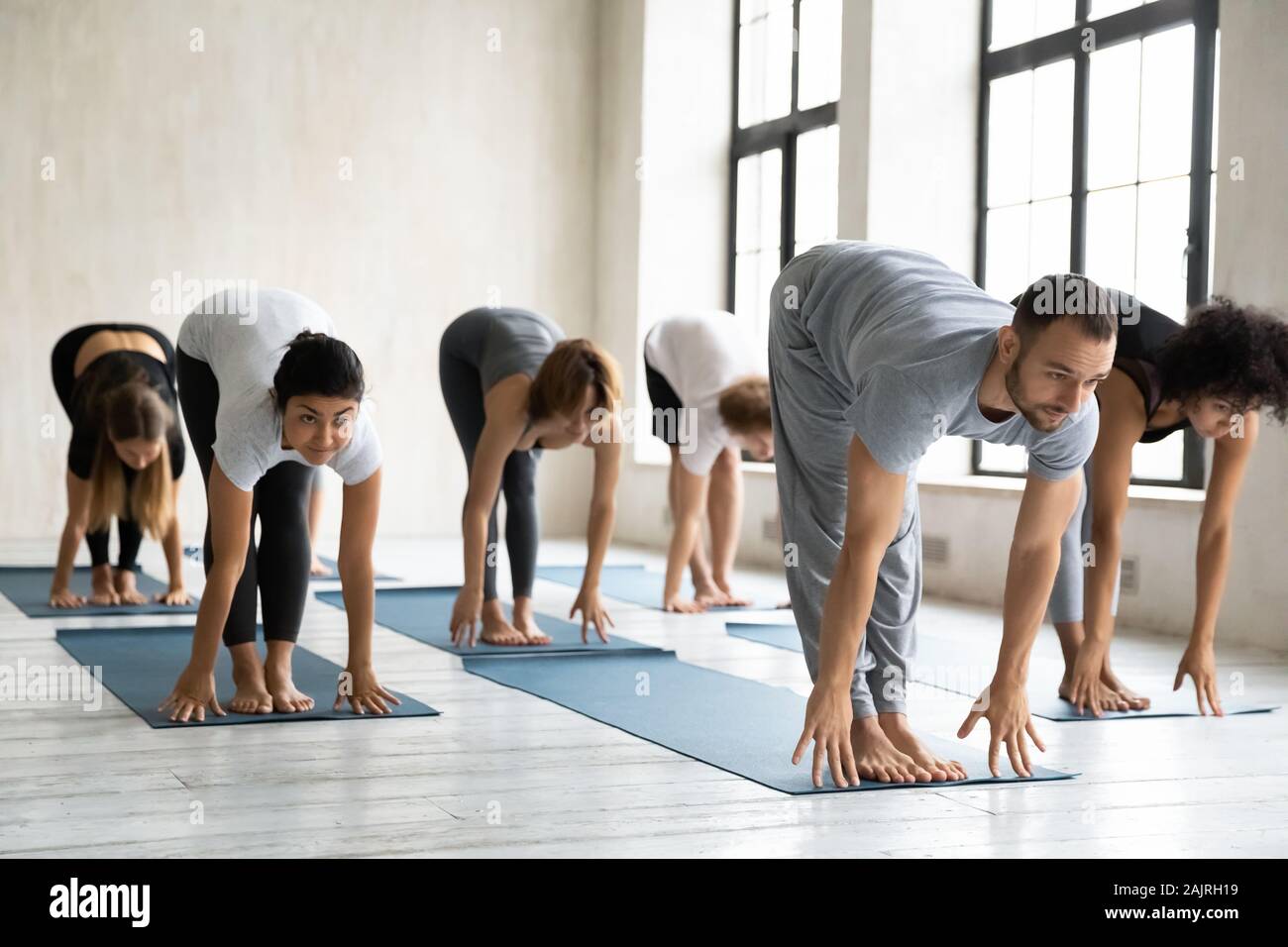 Diverse people doing half forward bend exercise, practicing yoga Stock ...