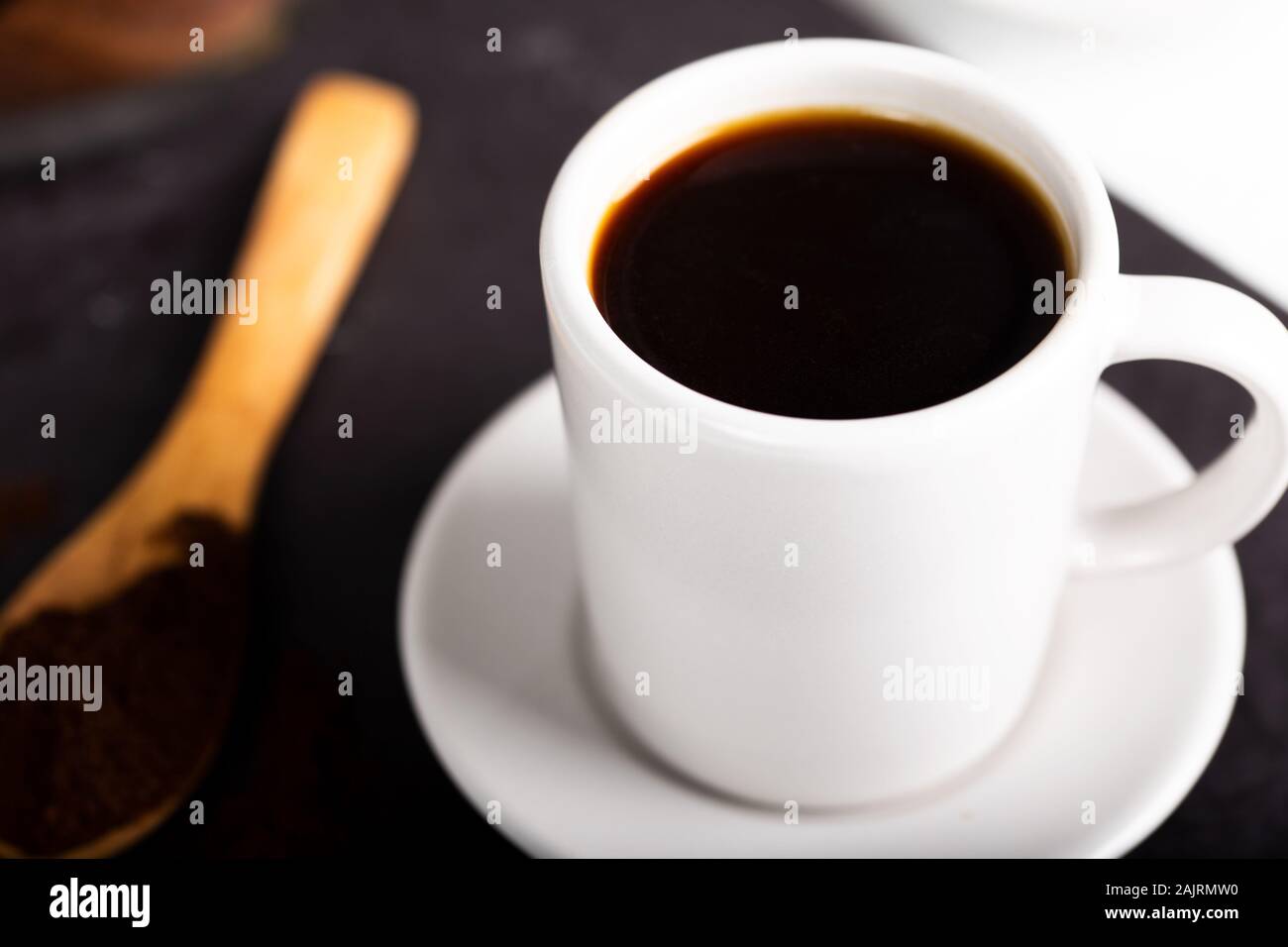 A coffee cup and a spoon spilling coffee powder Stock Photo - Alamy