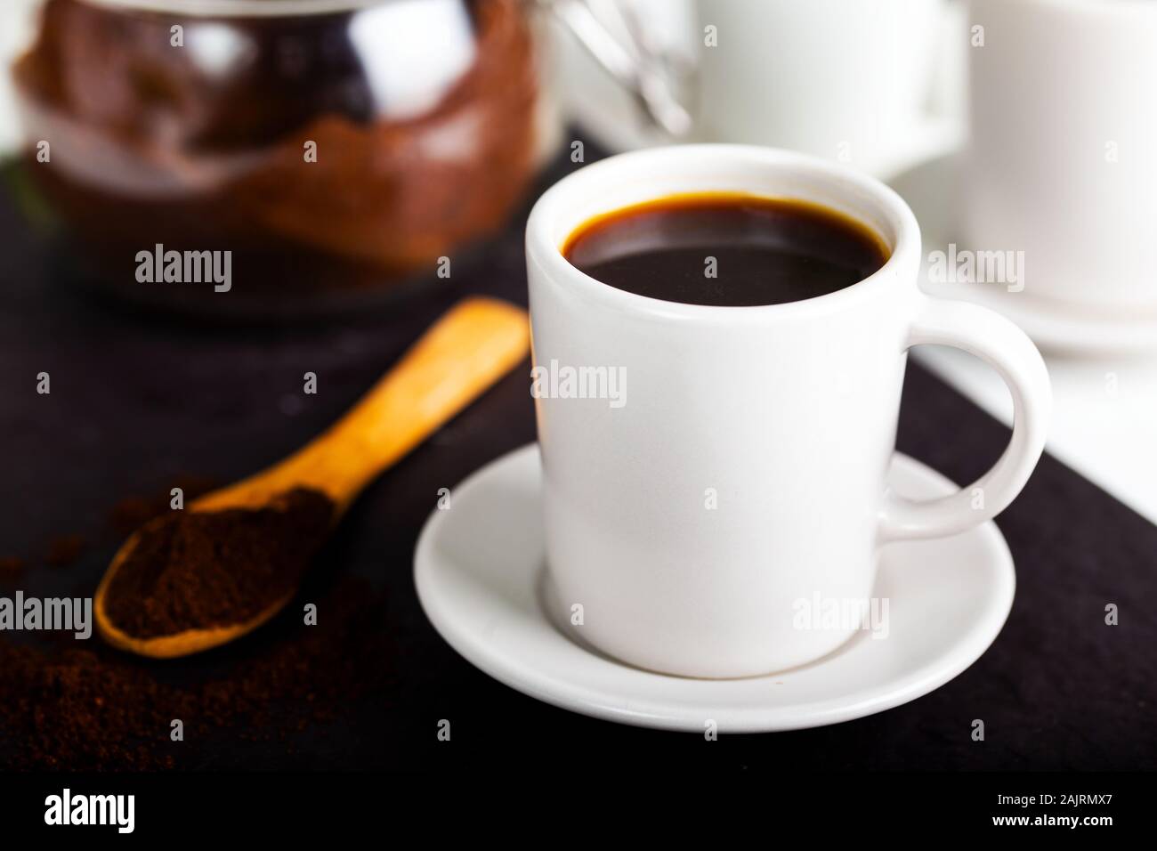 A coffee cup and a spoon spilling coffee powder Stock Photo - Alamy