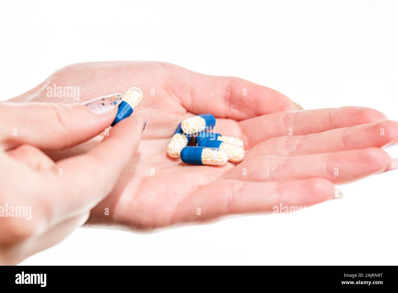 Hand holding antibiotics capsules or painkillers isolated on white ...