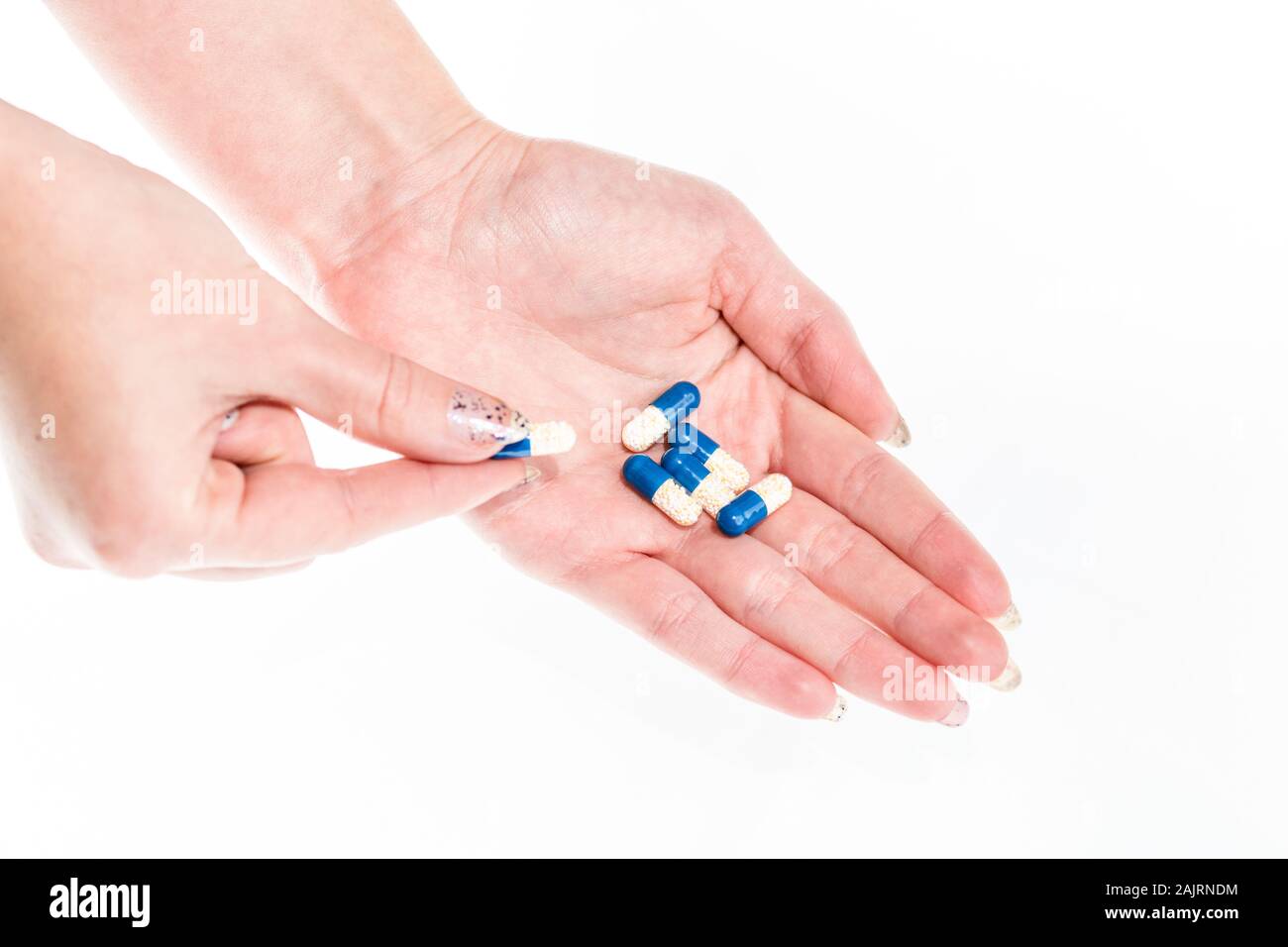 Hand holding antibiotics capsules or painkillers isolated on white ...