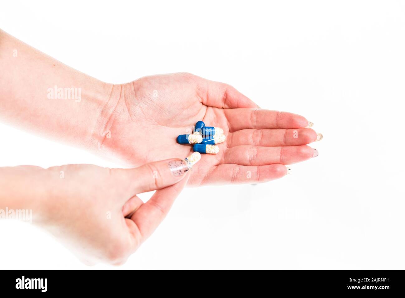 Hand holding antibiotics capsules or painkillers isolated on white ...