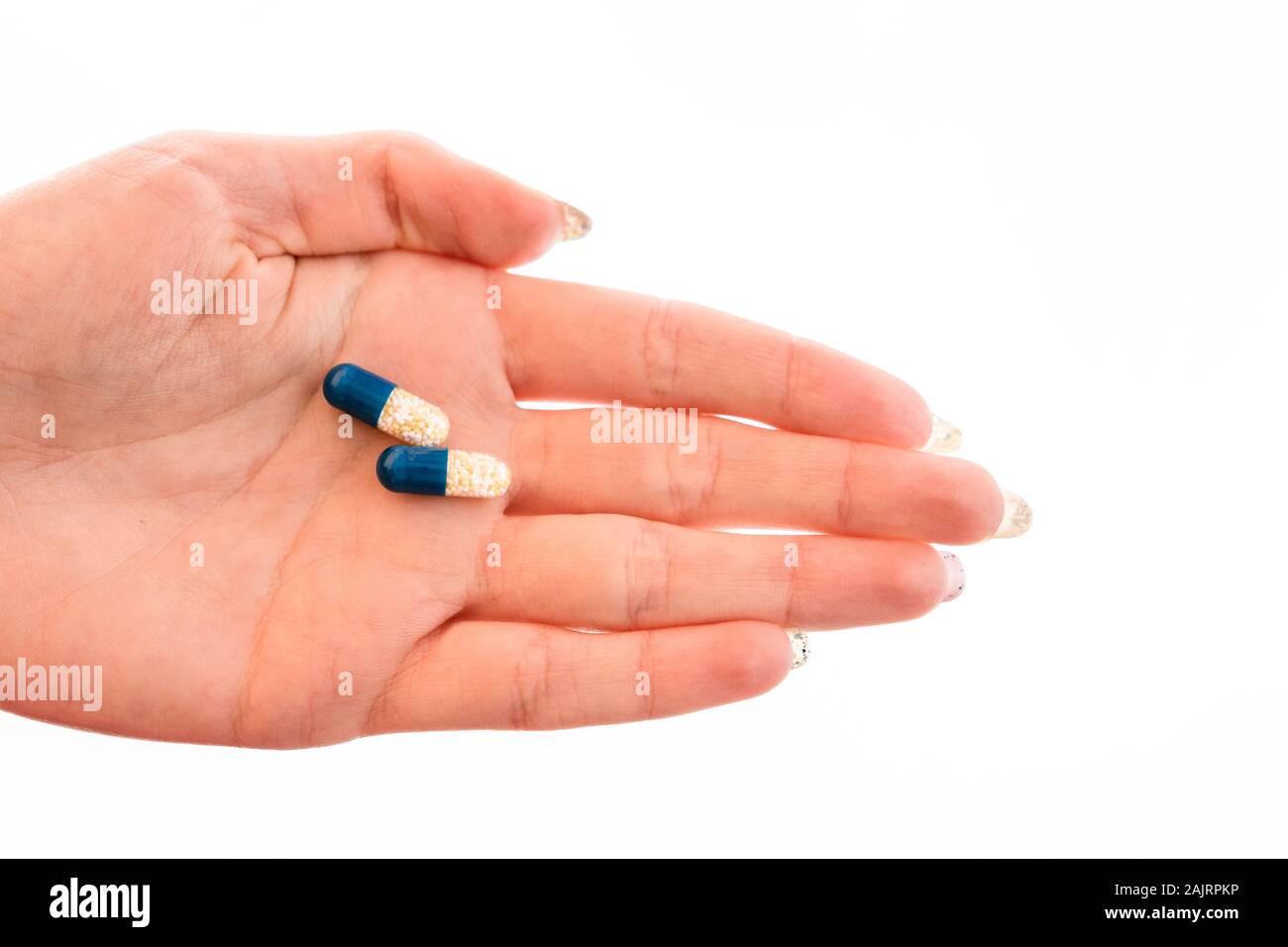 Hand holding antibiotics capsules or painkillers isolated on white ...