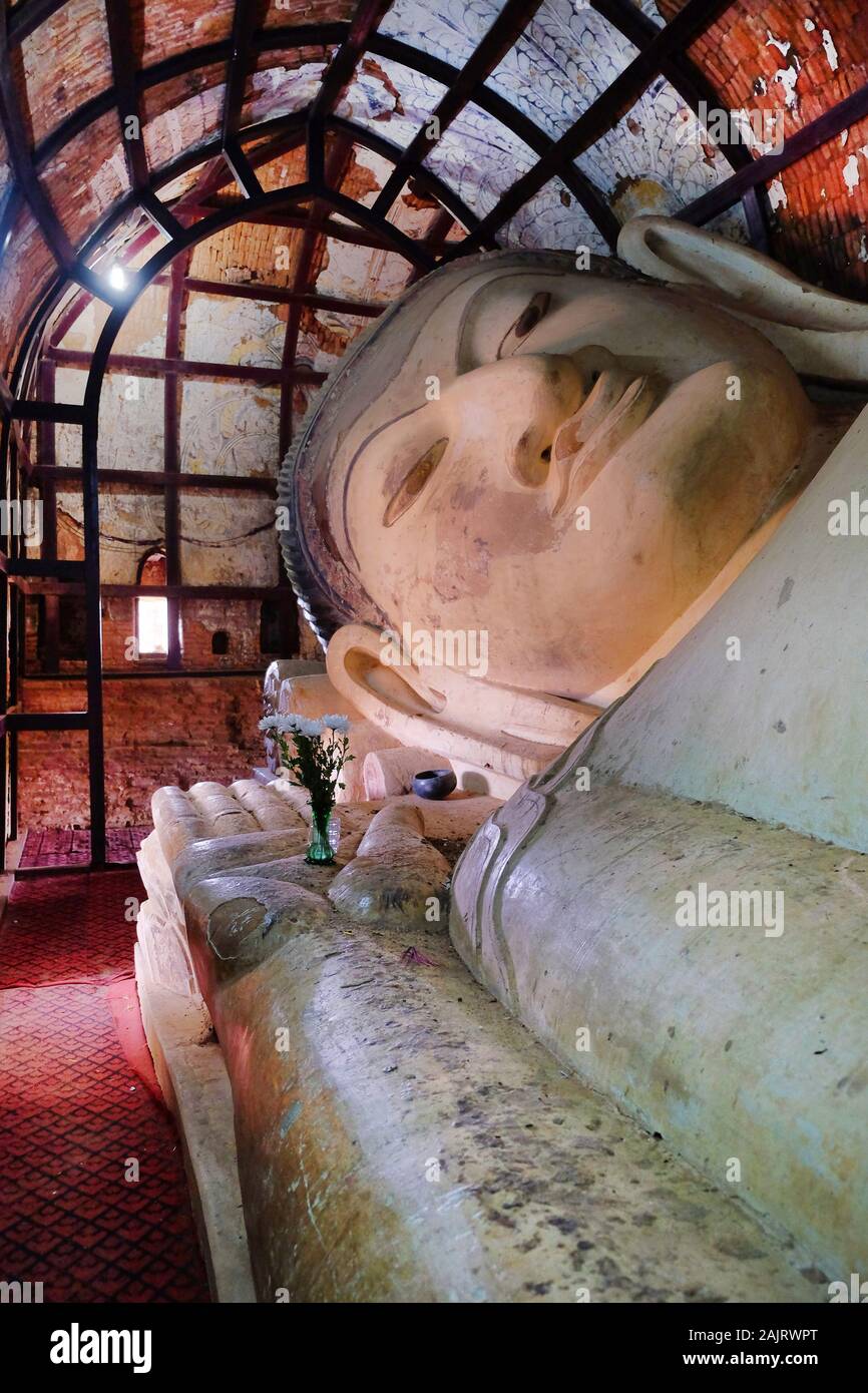 Ancient Buddha statue in a temple in old Bagan, Myanmar, covered in red ...