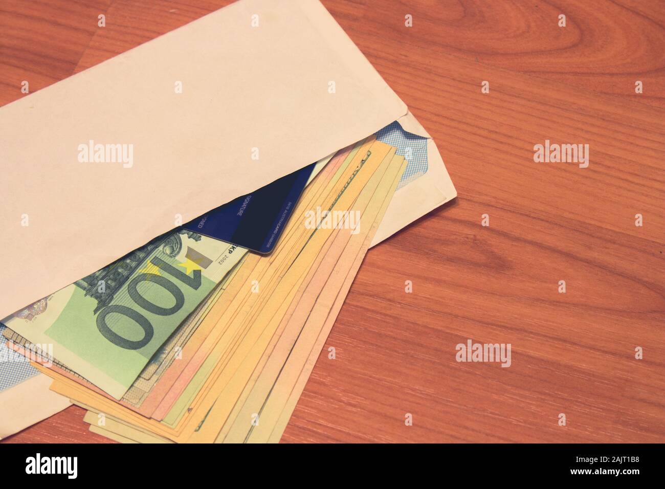Money and credit card in a envelope on the wooden desk Stock Photo - Alamy