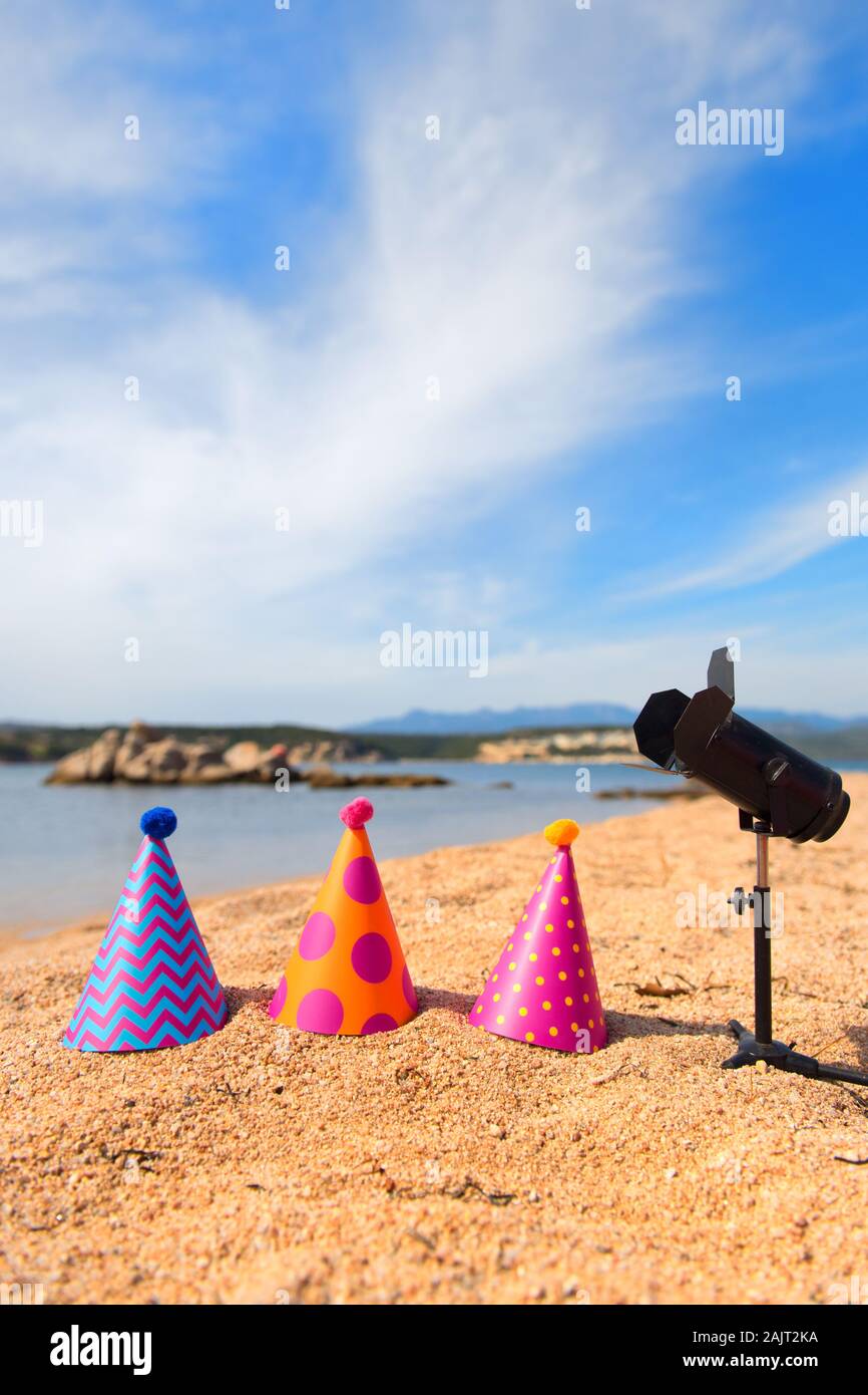 Colorful party hats at the beach with movie lights Stock Photo - Alamy