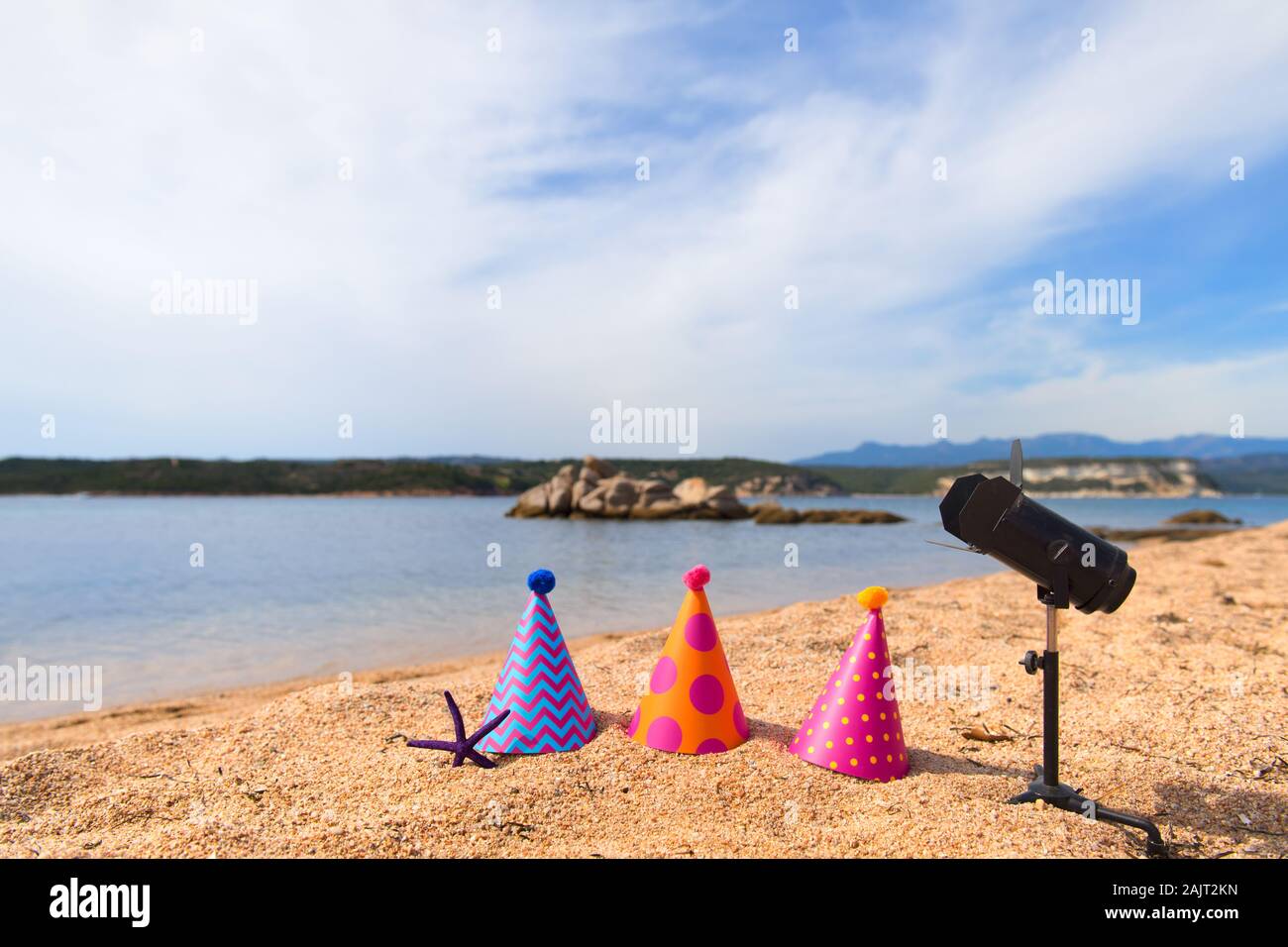 Colorful party hats at the beach with movie lights Stock Photo - Alamy