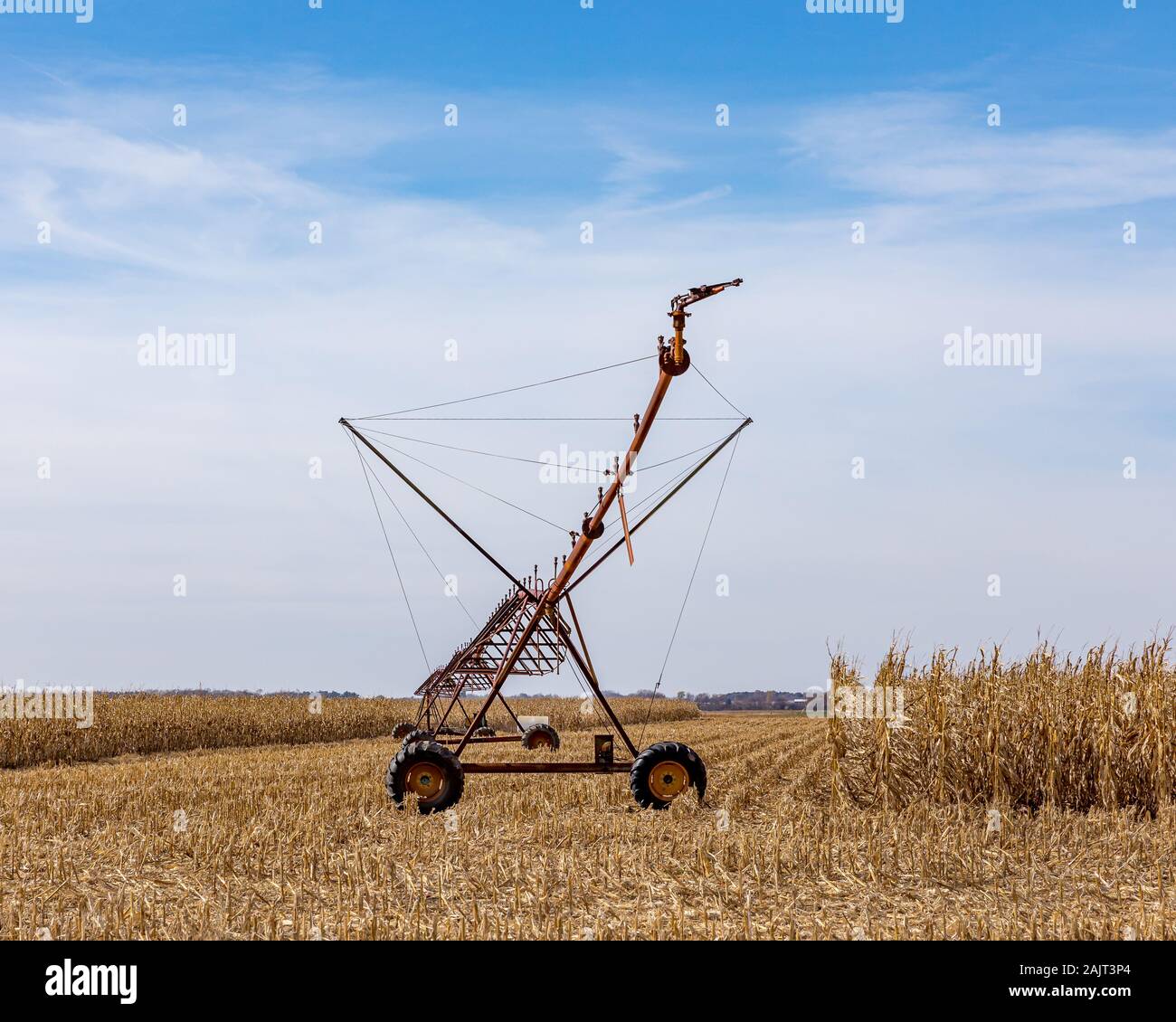 Rusty old center pivot irrigation system in cornfield with standing ...
