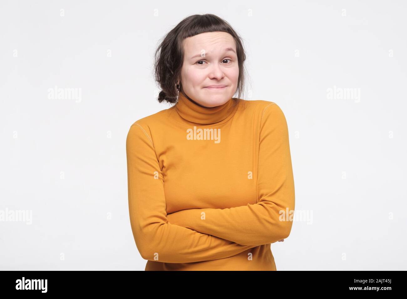 Confused female student in yellow clothes feeling awkward with weird ...