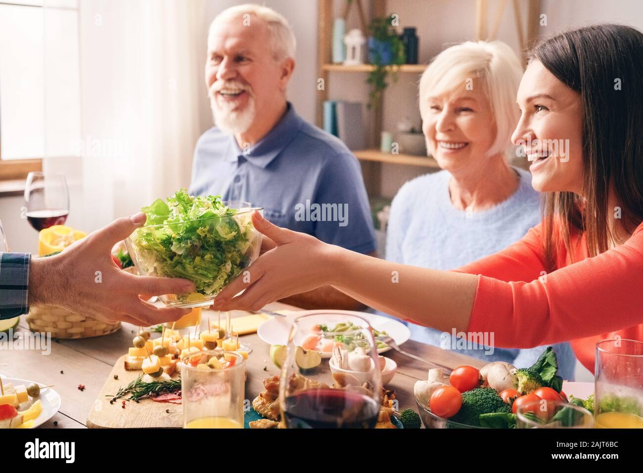 People sitting at home behind table, eating healthy food Stock Photo ...