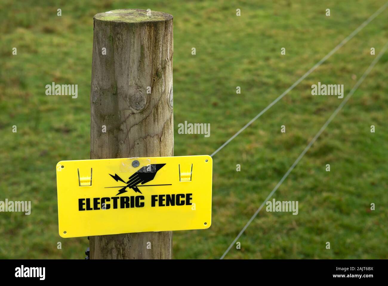 High visible yellow electric fence warning sign as part of power fence ...
