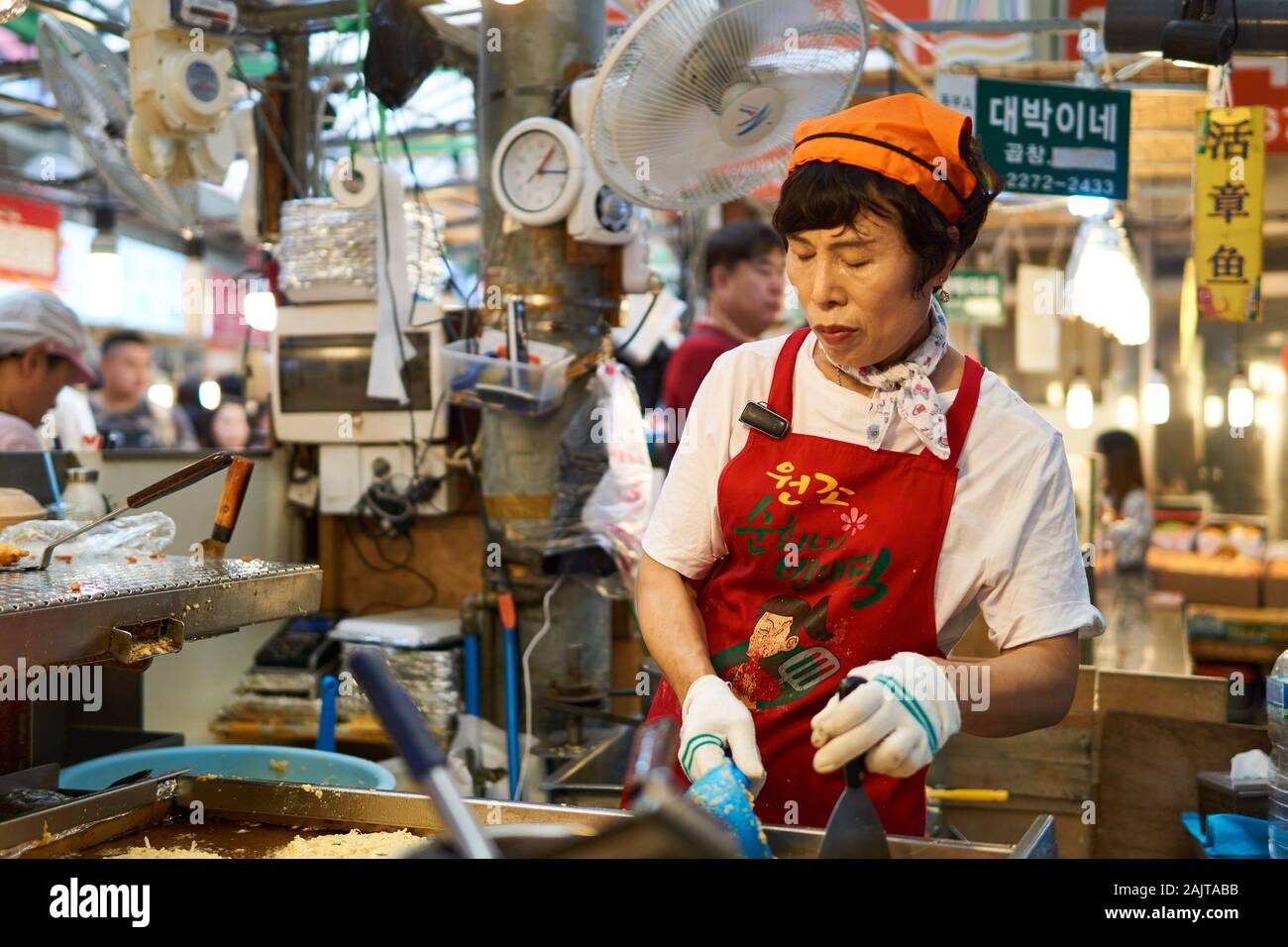 Mature female Korean chef prepares bindaetteok mung bean pancakes for ...