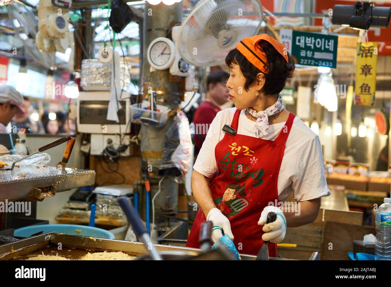 Mature female Korean chef prepares bindaetteok mung bean pancakes for ...