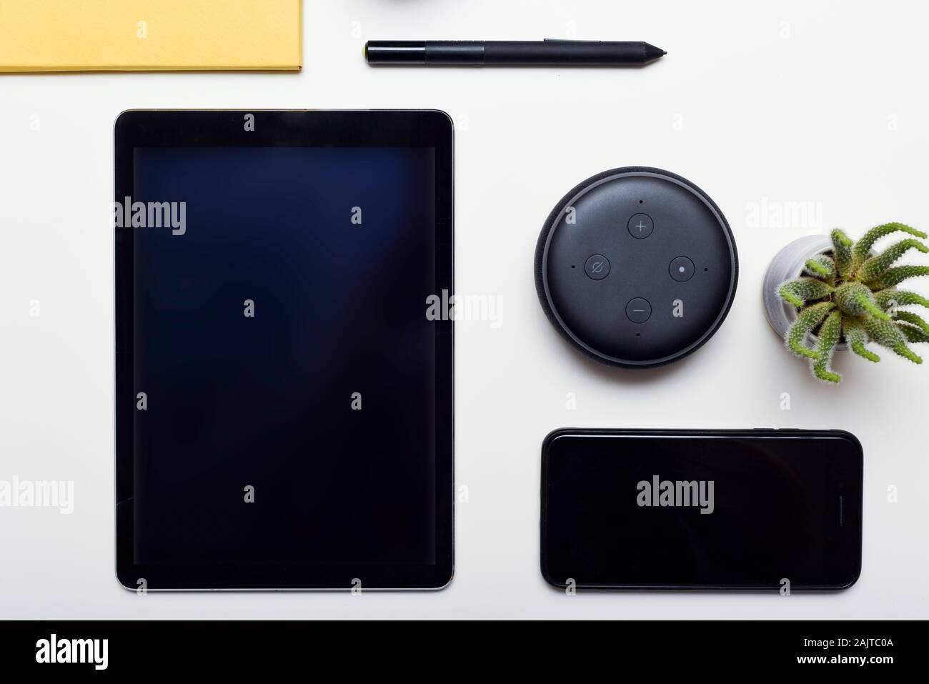 Digital and wireless technology objects arranged on a white desk ...