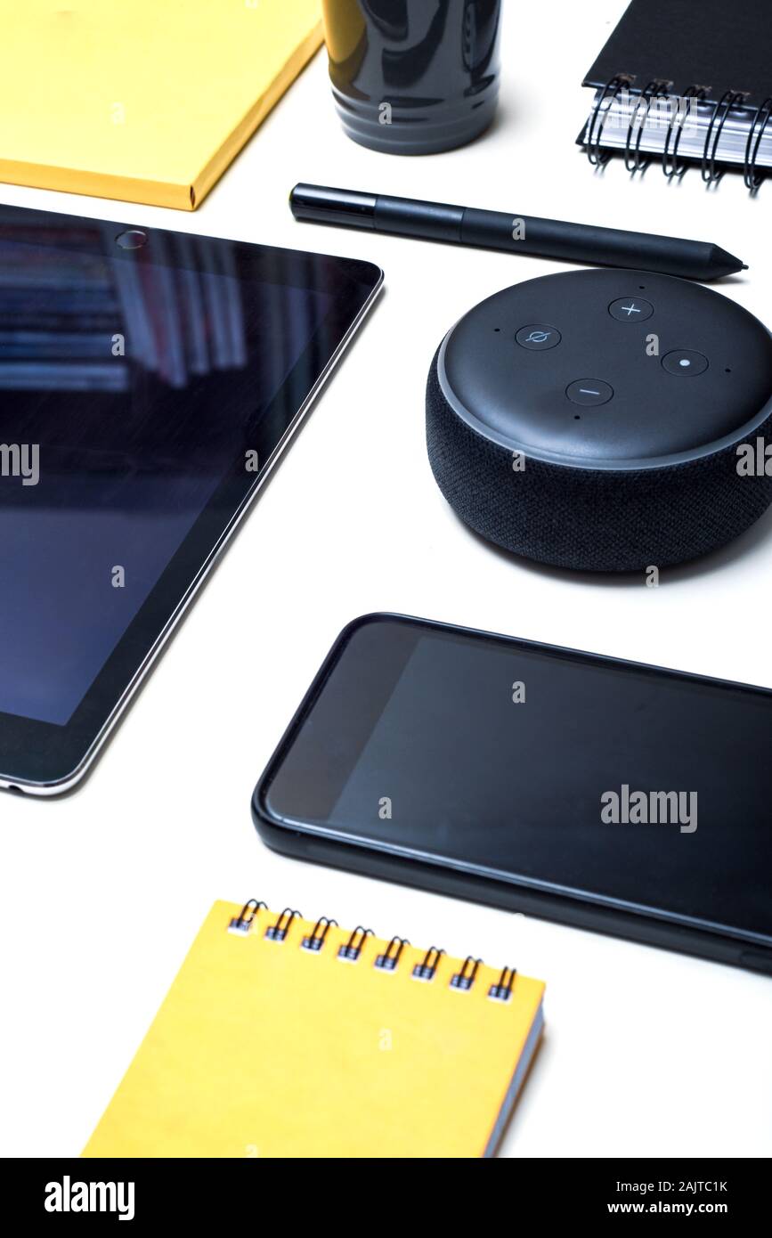 Digital and wireless technology objects arranged on a white desk ...