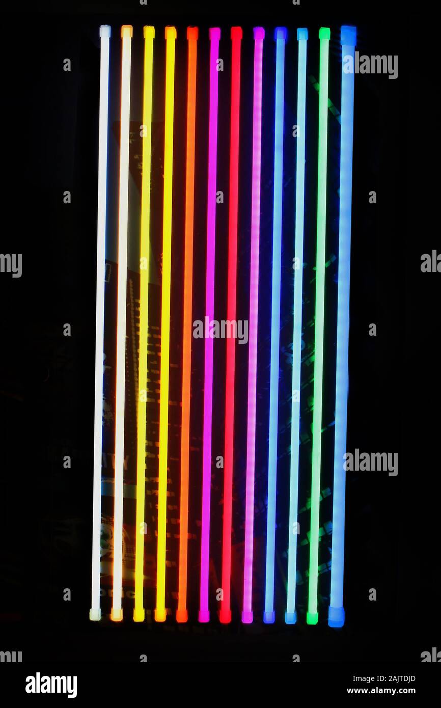Colorful glowing light sticks on black wall Stock Photo - Alamy