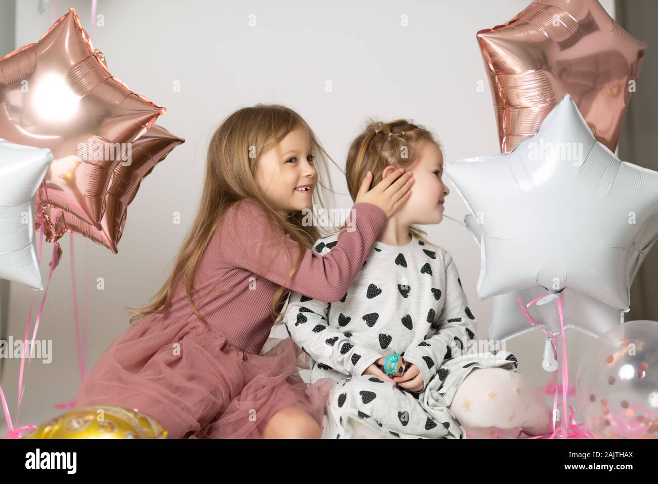 Whispering A Secret. Preschool girl telling her friend some gossips ...