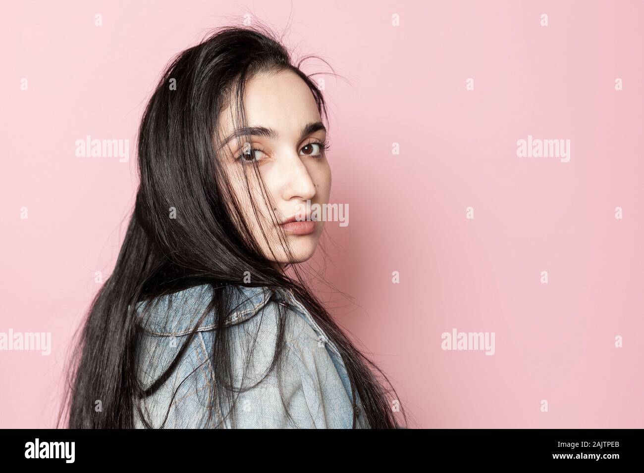 Portrait of happy middle-eastern female posing against a pink background. Studio portrait of a ...