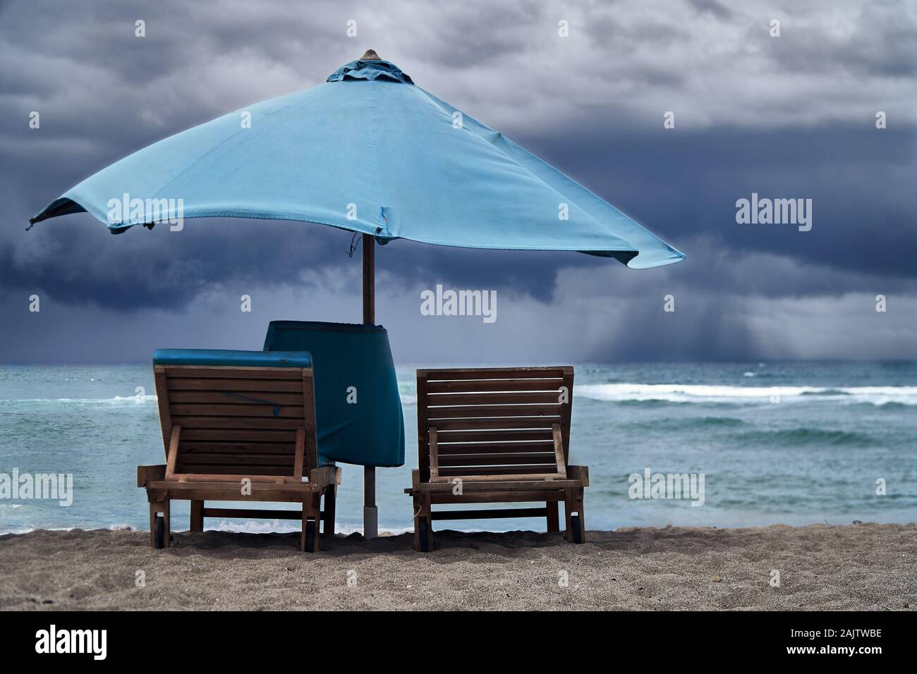 Storm on the sea with thunderclouds. Empty beach with umbrella and sun ...