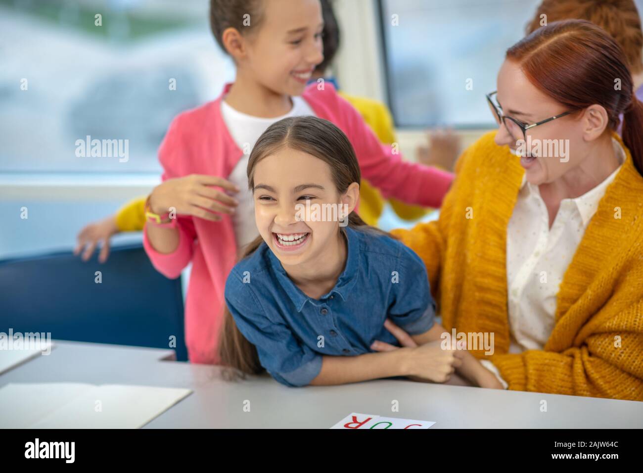 Laughing teacher having fun with her schoolgirl Stock Photo - Alamy