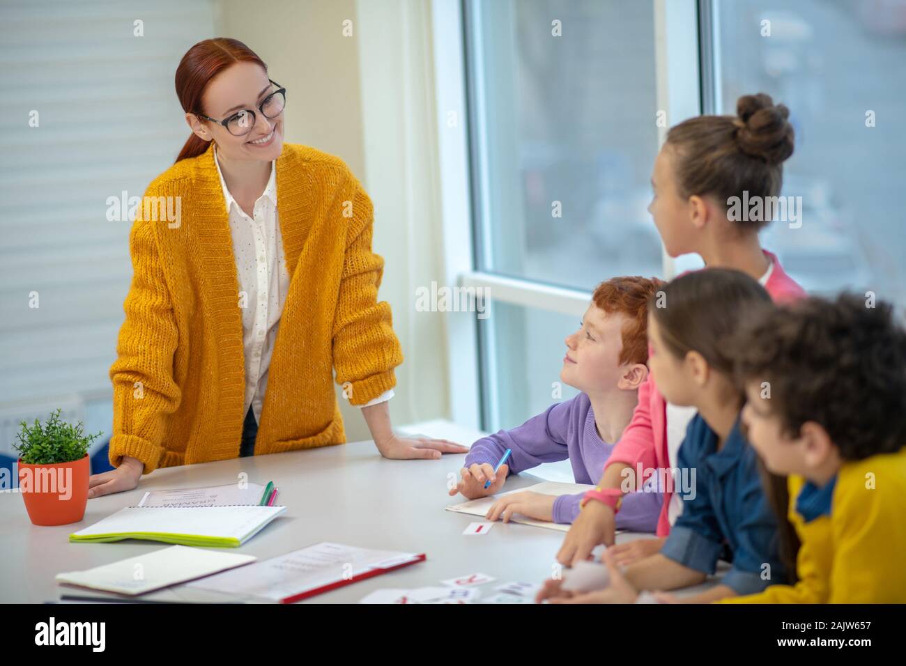 Smiling teacher working with primary school students Stock Photo - Alamy