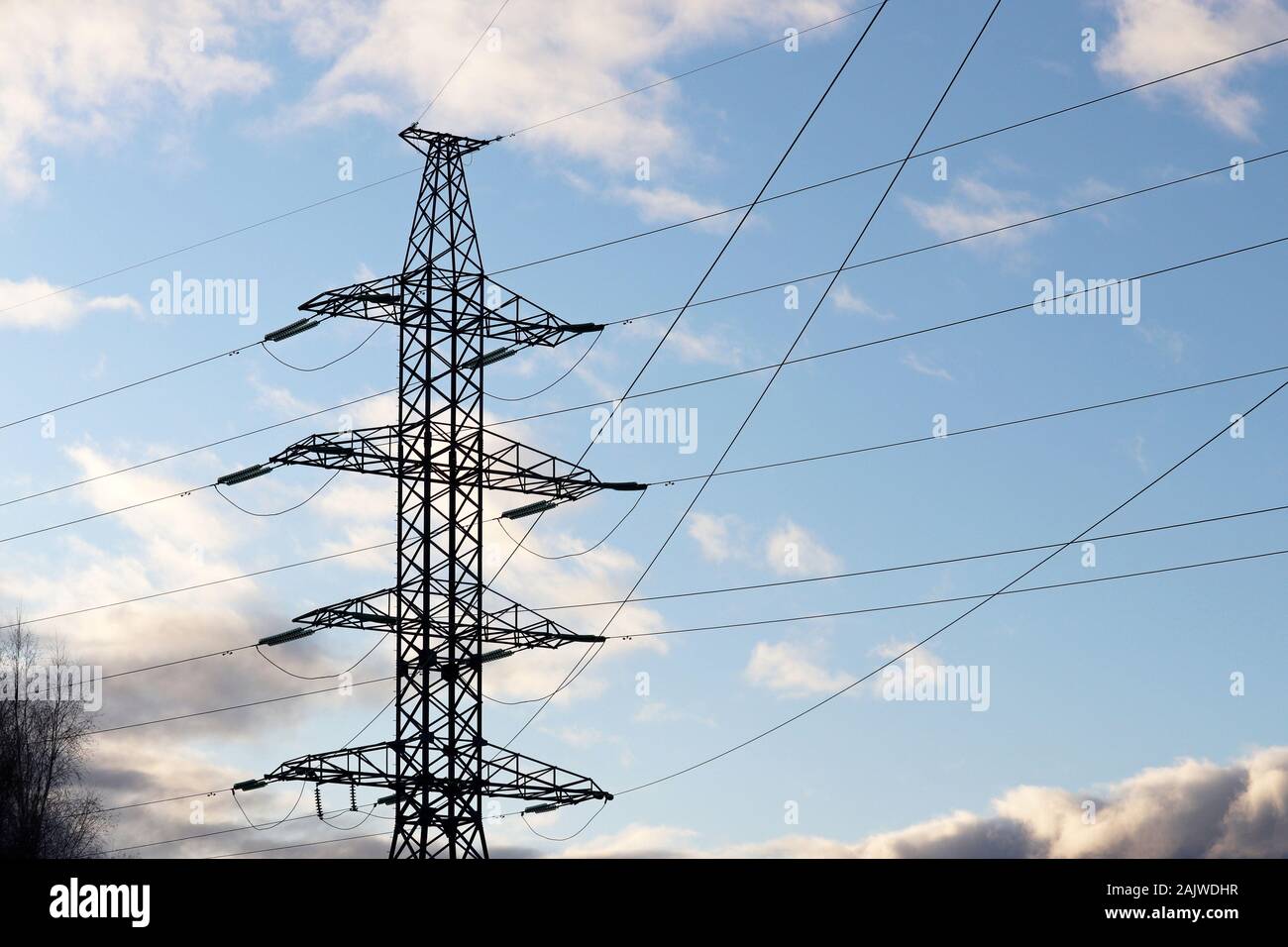 High voltage power line support with electrical wires on cloudy sky ...