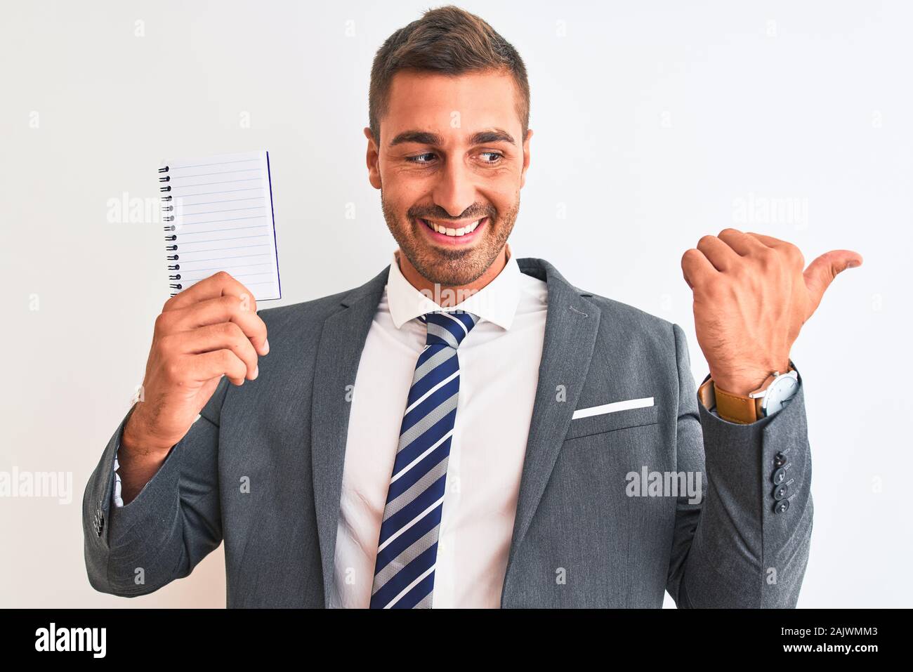 Young handsome business man holding blank notebook over isolated ...