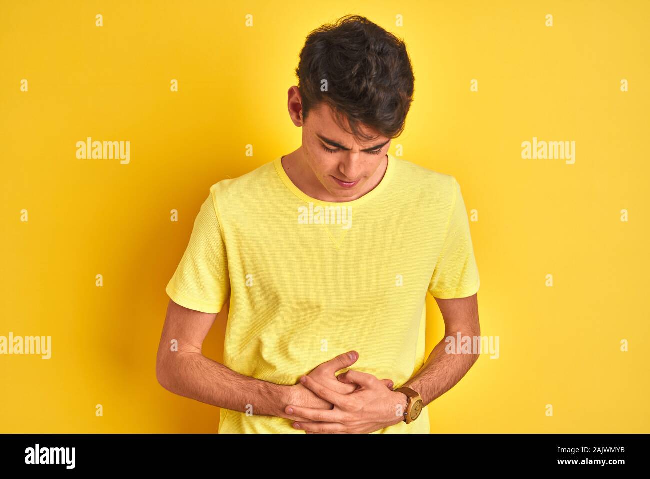 Teenager boy wearing yellow t-shirt over isolated background with hand ...