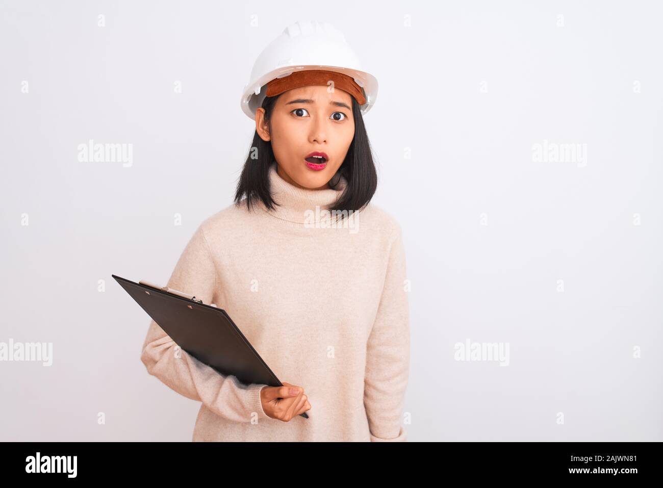 Chinese architect woman wearing helmet holding clipboard over isolated ...