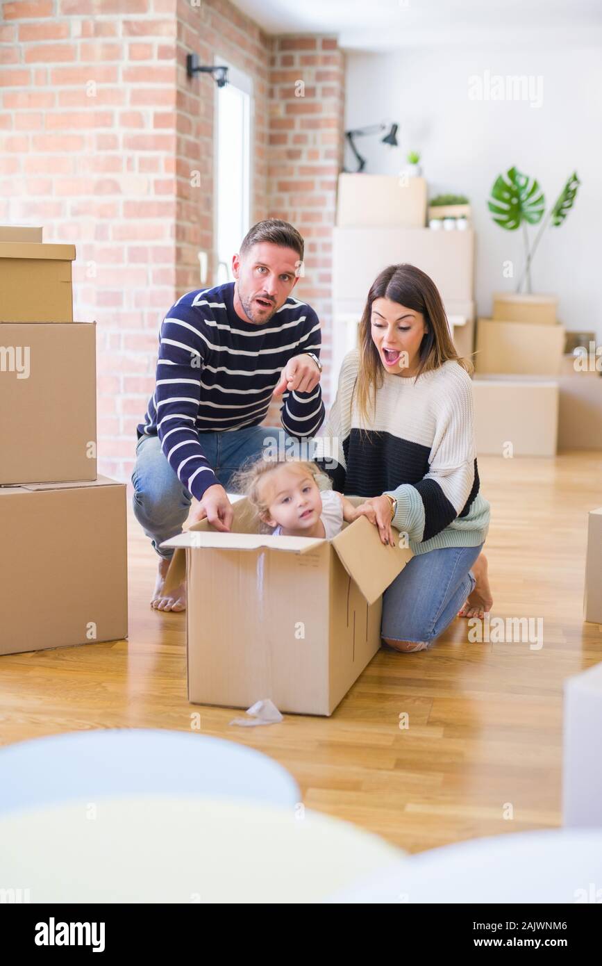 Beautiful famiily, kid playing with his parents riding cardboard fanny ...