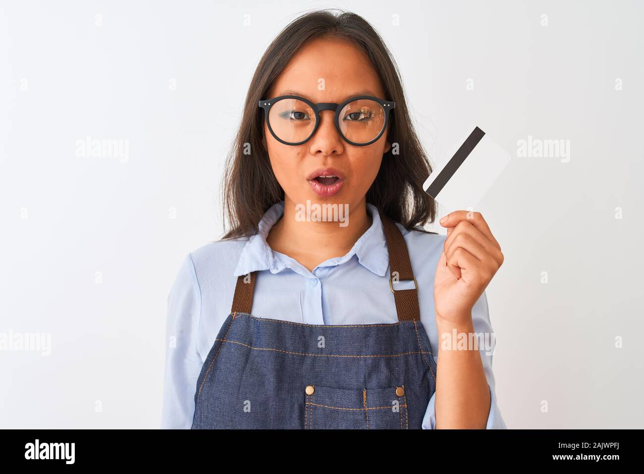 Chinese shopkeeper woman wearing glasses holding credit card over ...