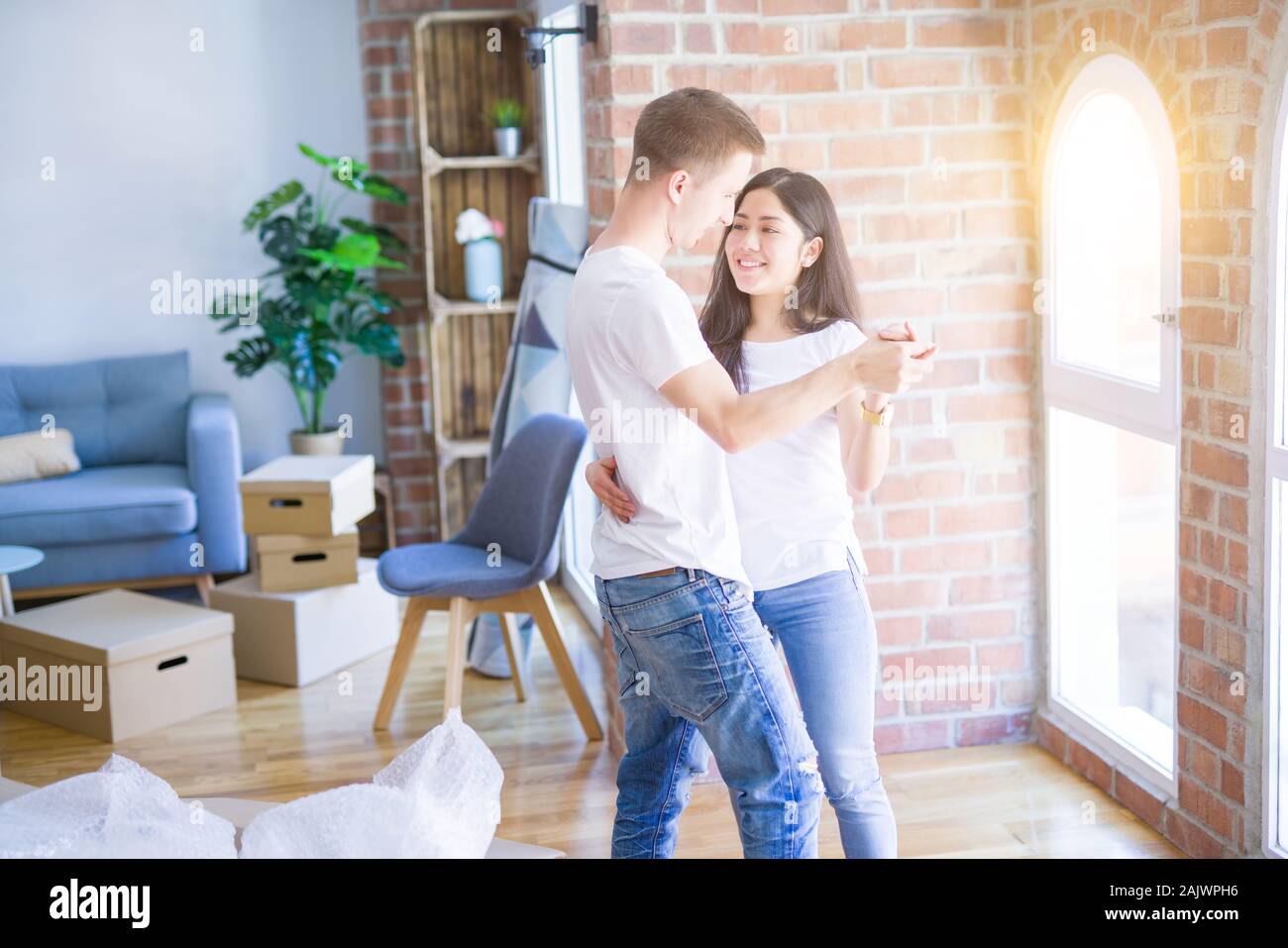 Young beautiful couple dancing at new home around cardboard boxes Stock ...