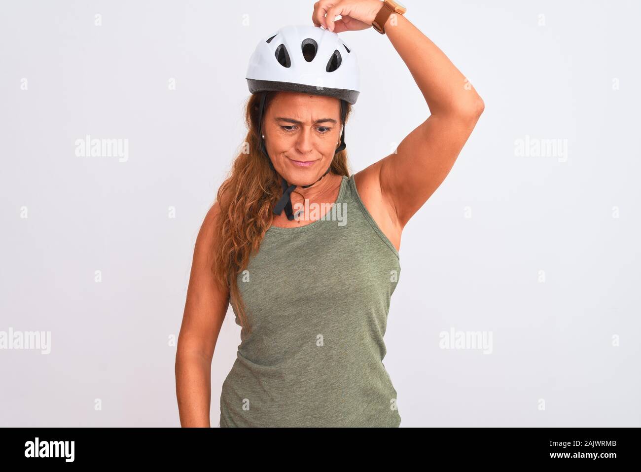 Middle age mature cyclist woman wearing safety helmet over isolated ...