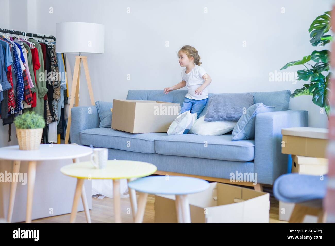 Beautiful toddler child girl jumping on the sofa Stock Photo - Alamy