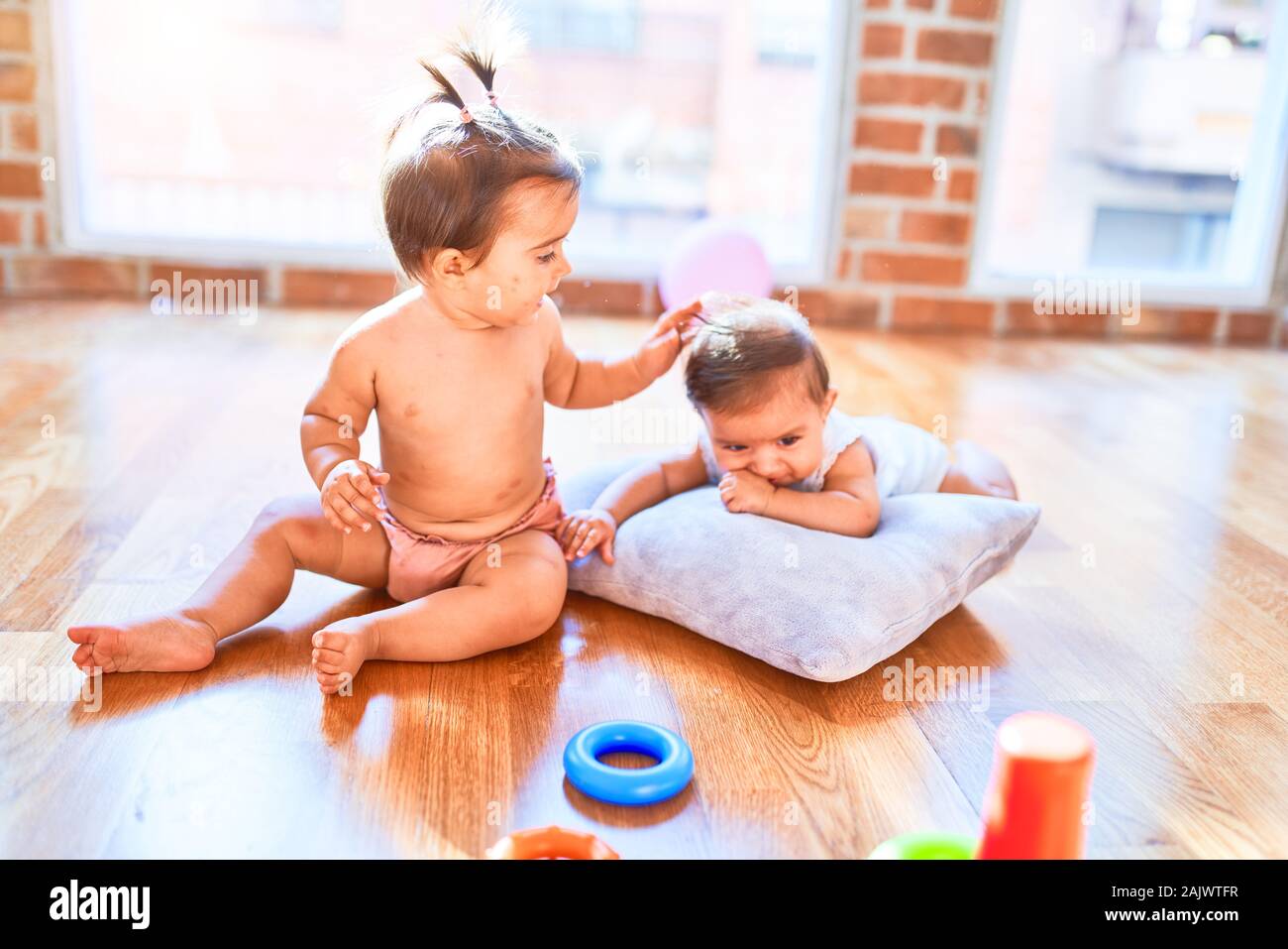 Beautiful infant happy girls playing together at home kindergarten ...