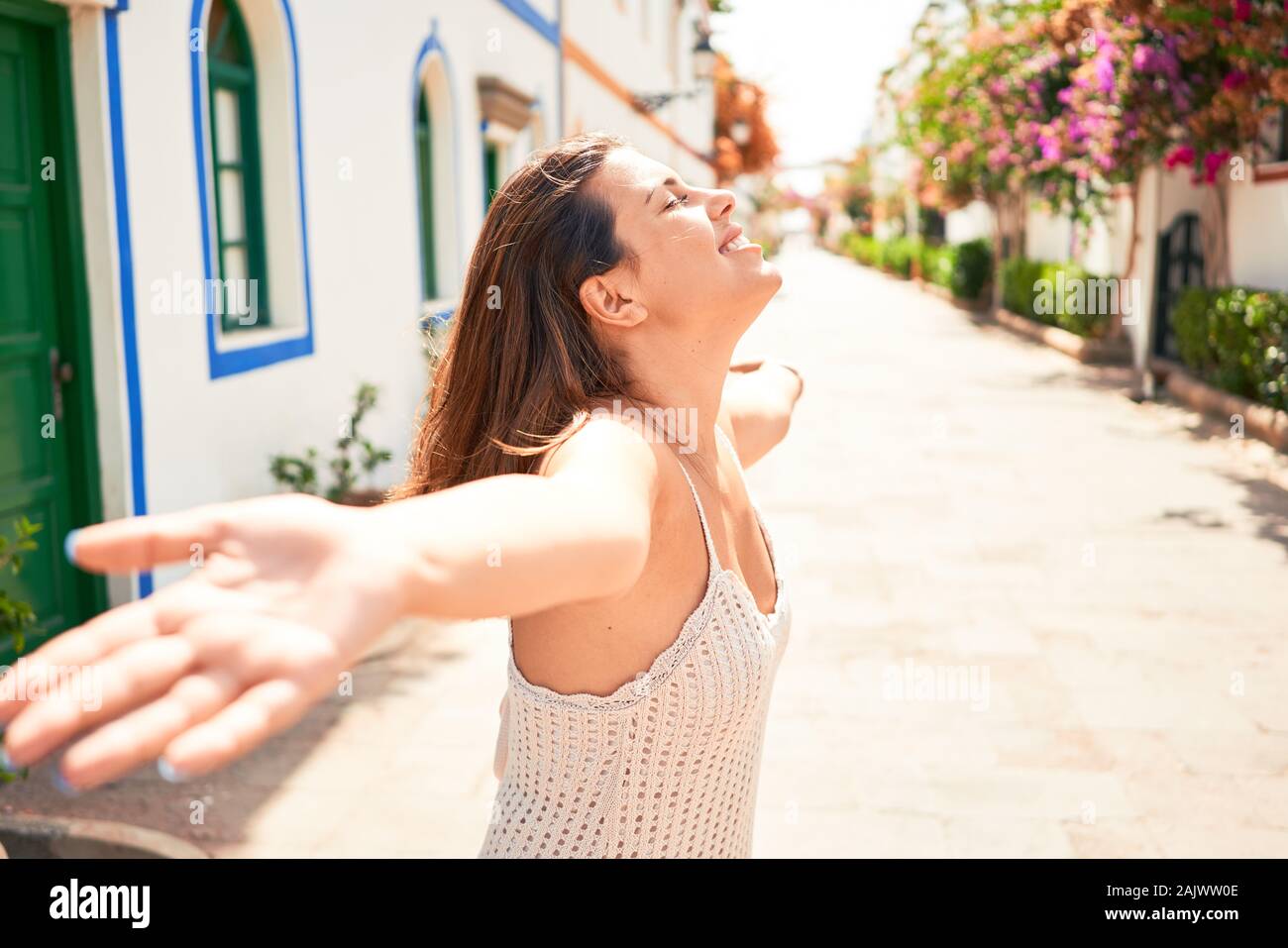 Young beautiful woman at the colorful village of Puerto de Mogan ...