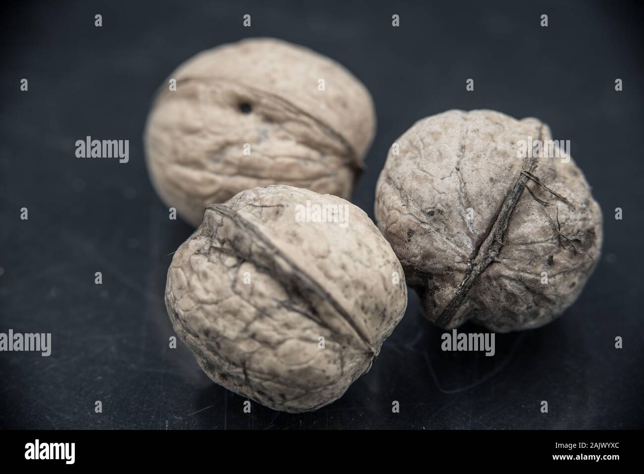 Three nuts against black background Stock Photo - Alamy