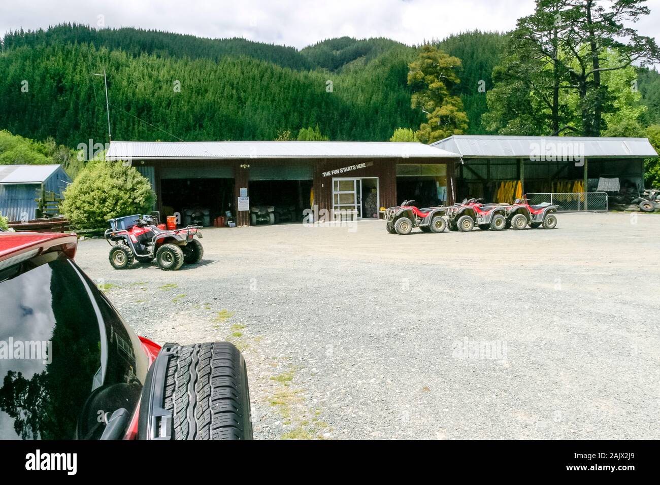 Red quad bikes lined up outside buildings at Cable Bay adventure Park ...