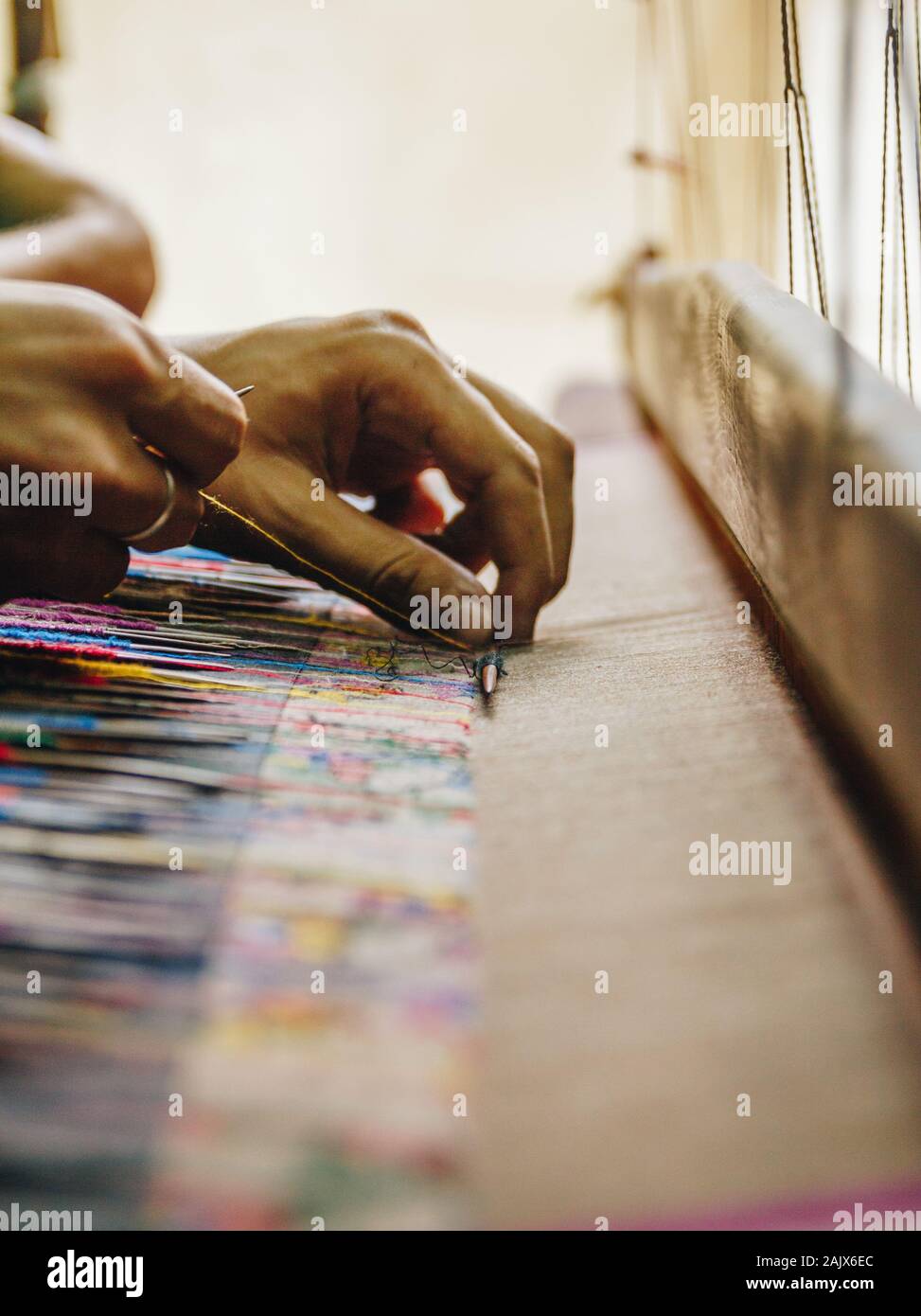 Hand weaving a colorful kashmiri pashmina shawl with light source ...