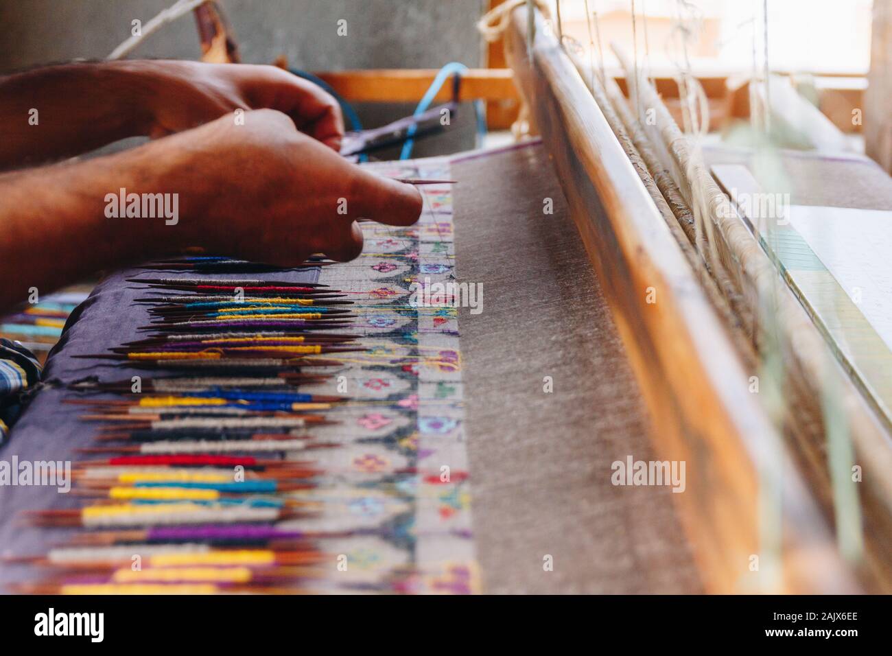 Hand weaving a colorful kashmiri pashmina shawl with light source ...