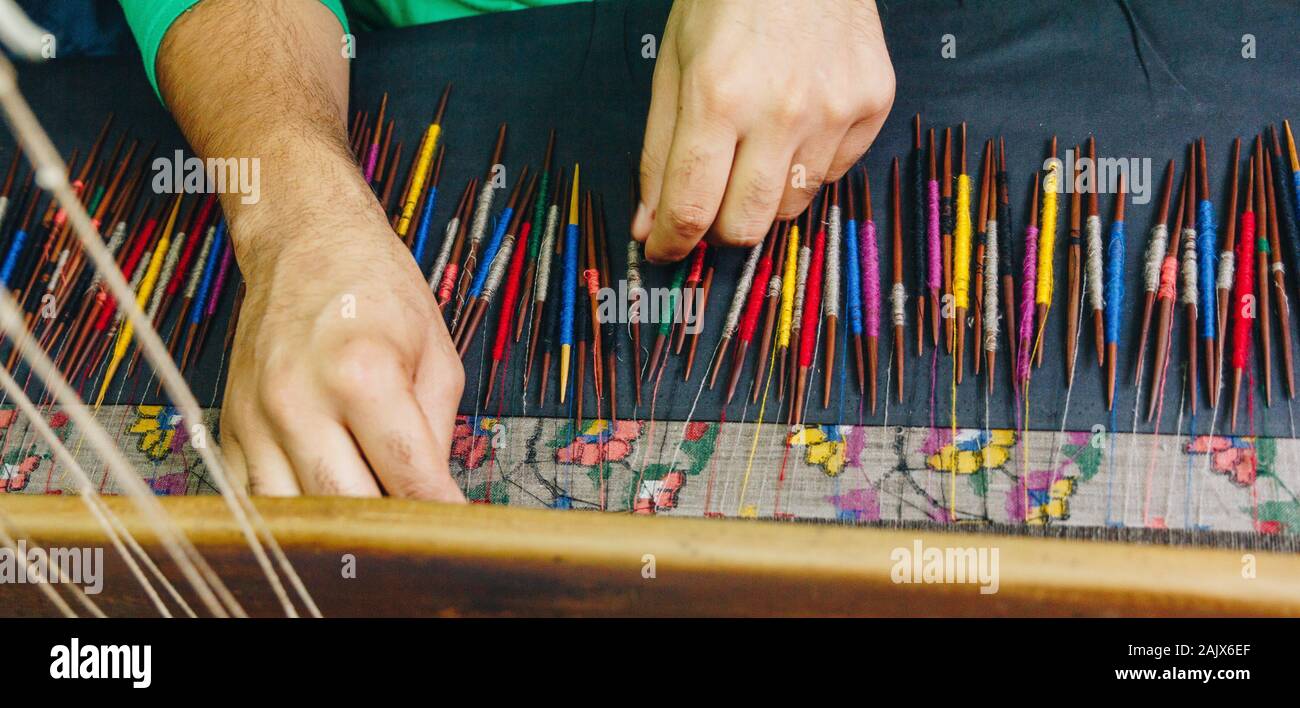 Hand weaving a colorful kashmiri pashmina shawl with light source ...