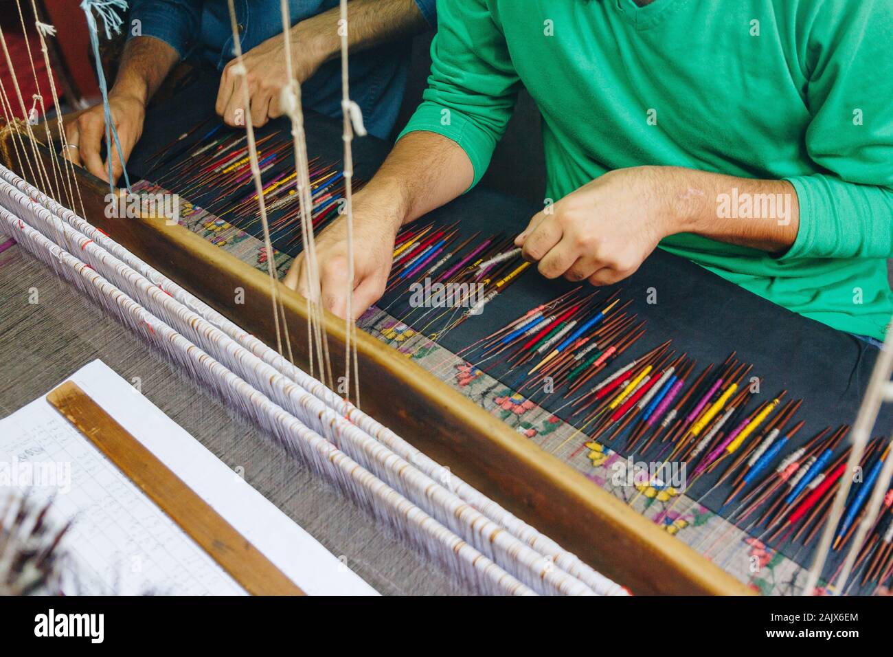 Hand weaving a colorful kashmiri pashmina shawl with light source ...