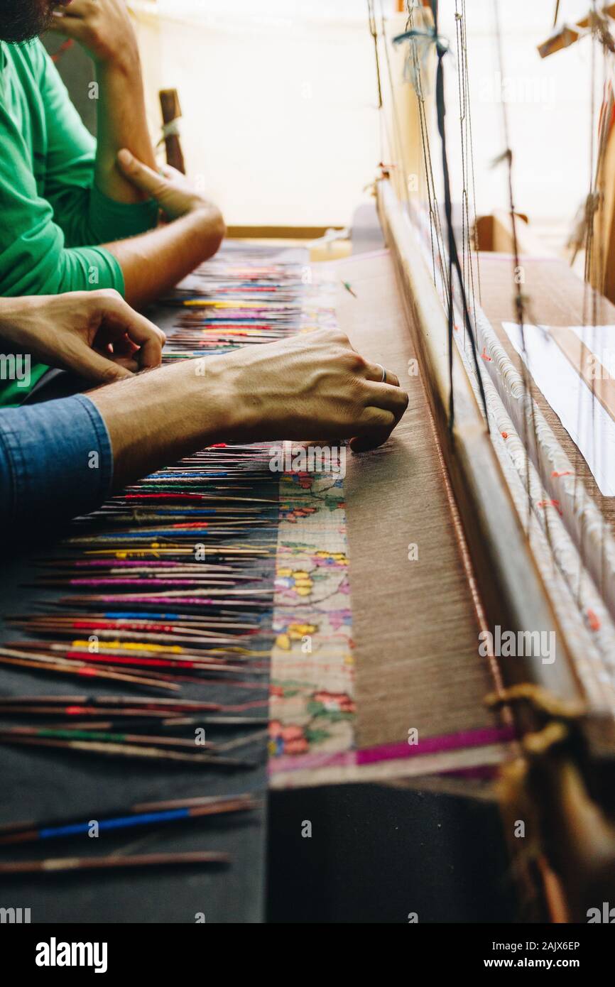 Hand weaving a colorful kashmiri pashmina shawl with light source ...