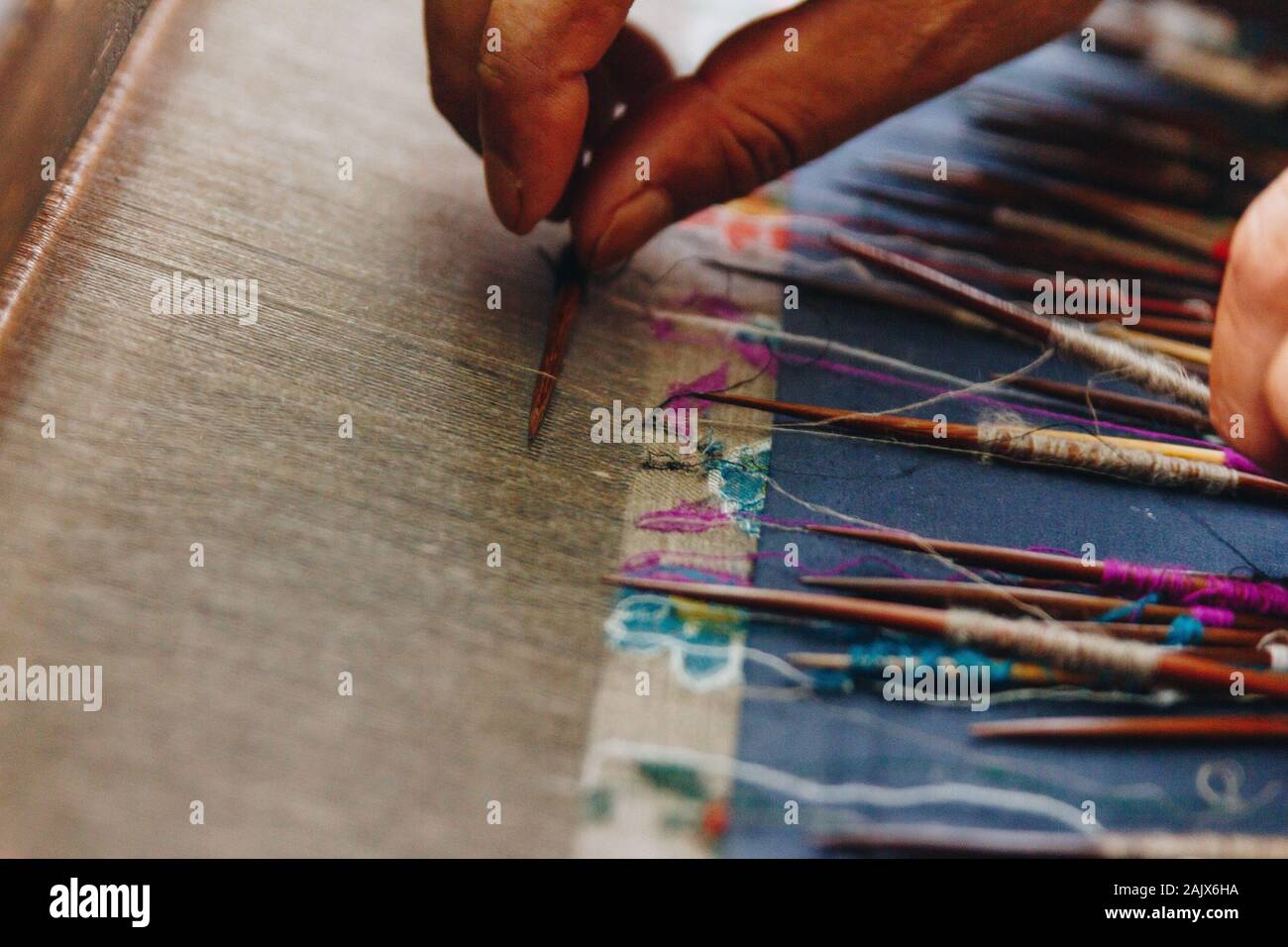 Hand weaving a colorful kashmiri pashmina shawl with light source ...