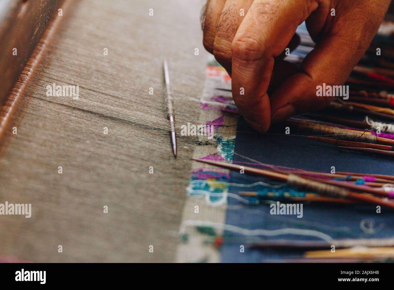 Hand weaving a colorful kashmiri pashmina shawl with light source ...