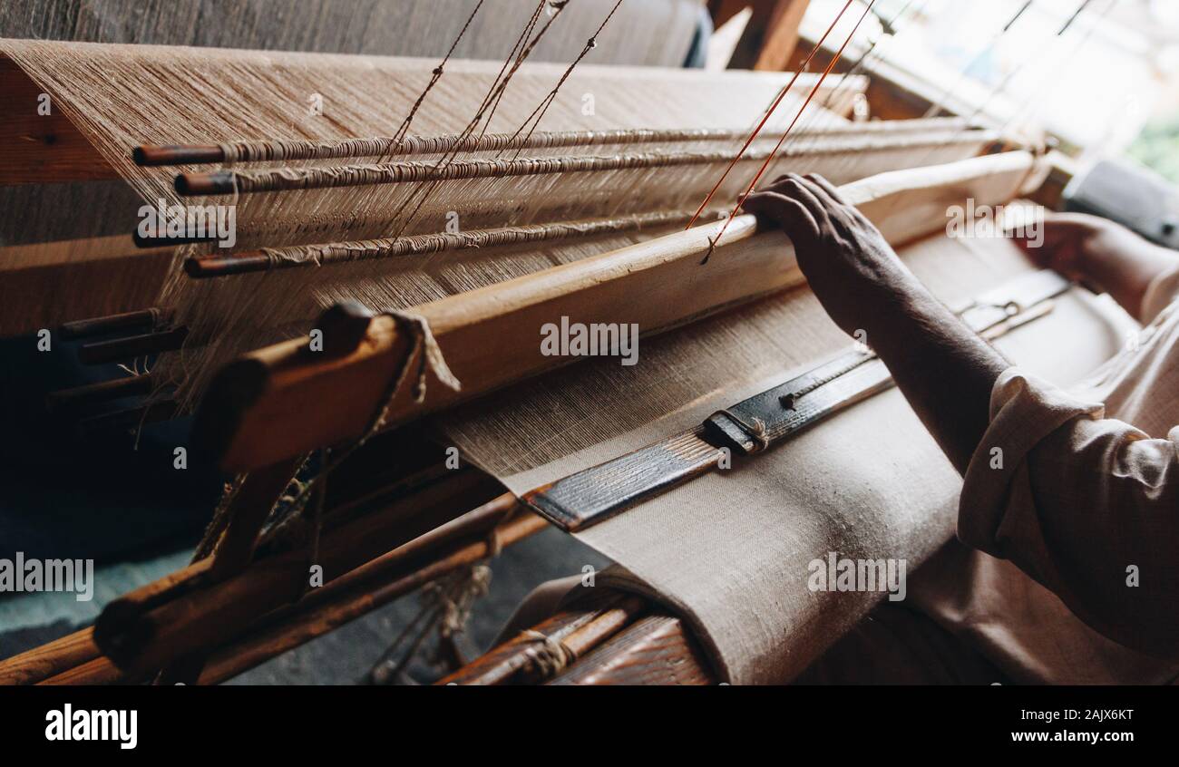 Hand weaving a kashmiri pashmina shawl with light source coming from ...