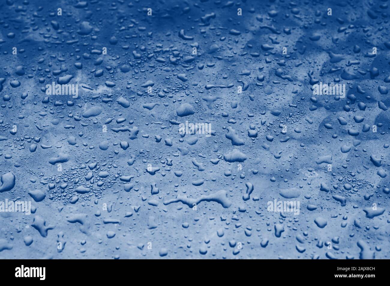 blue water drops texture on the glass background. Classic blue toning ...