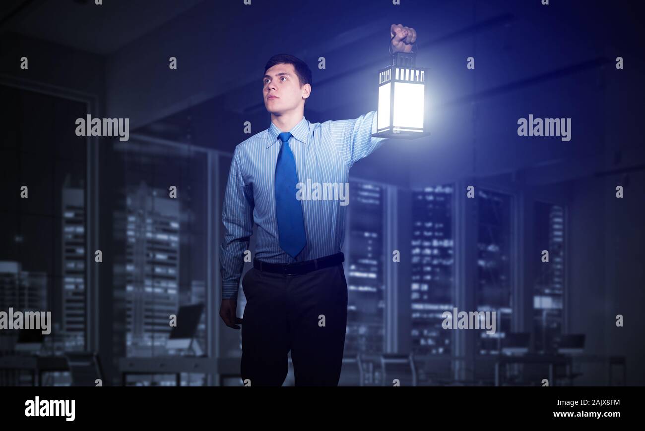 Scared businessman holding glowing lantern Stock Photo - Alamy